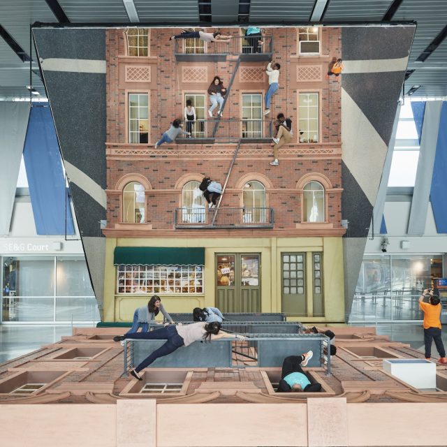 This art installation makes it look like visitors are climbing a four ...